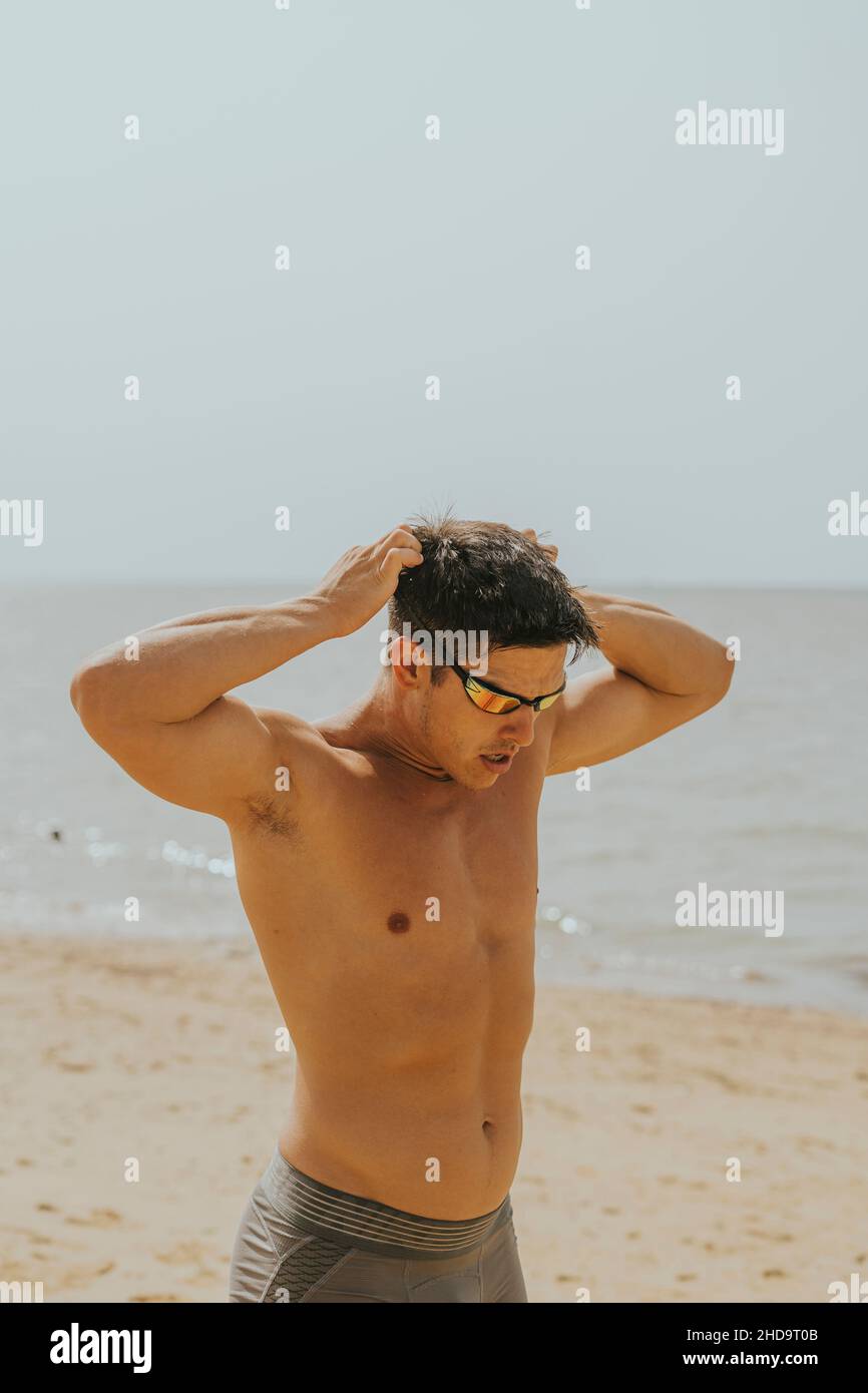 Young Spanish sporty male waring swimming goggles on the beach Stock ...