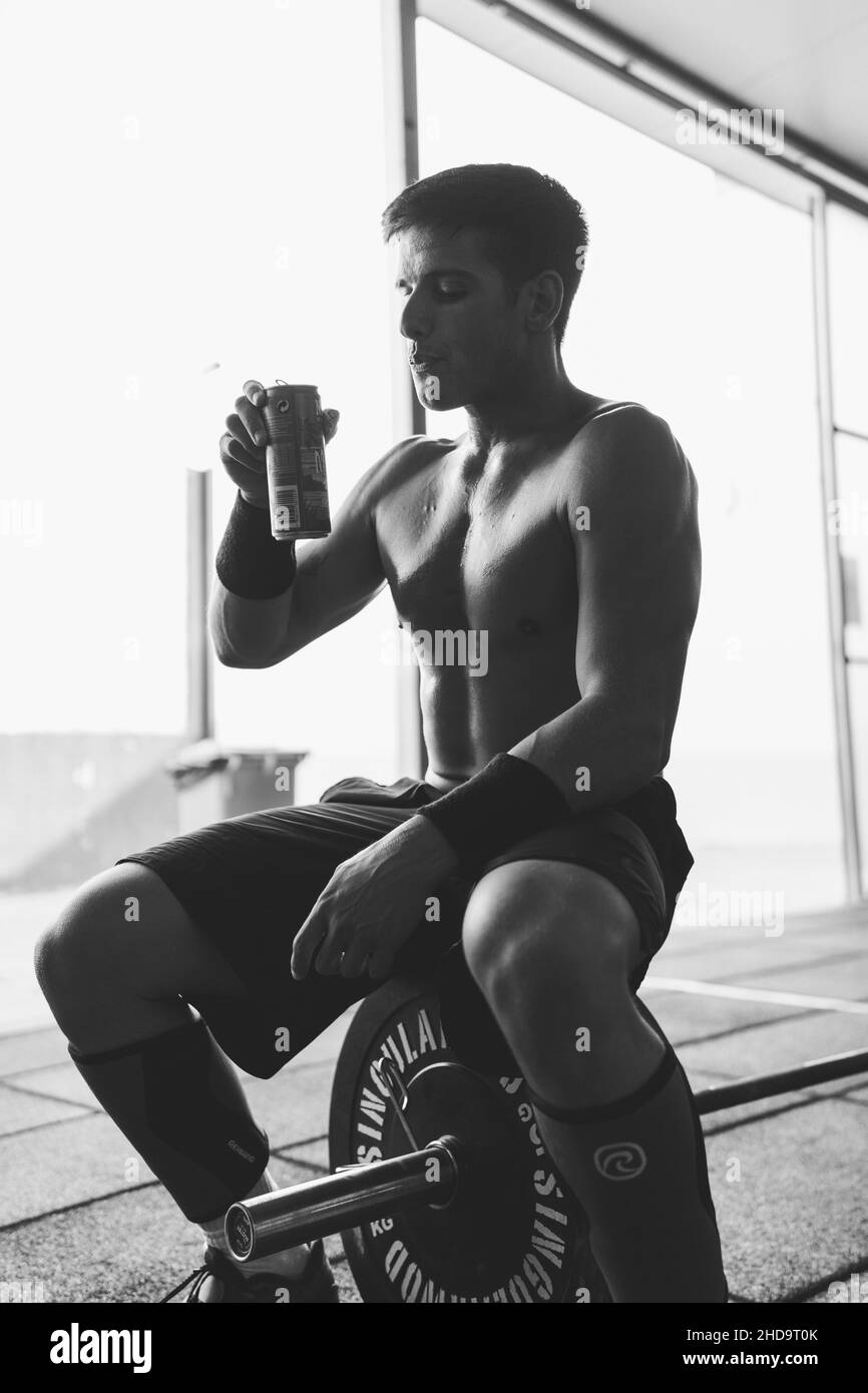 Young Spanish muscular male athlete having rest after hard training in ...