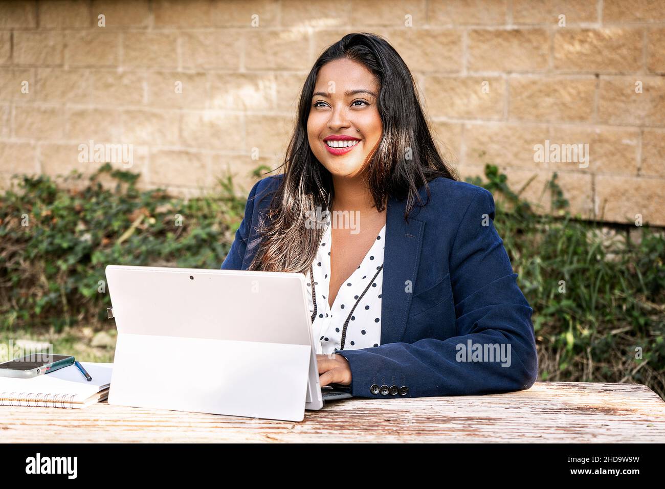 latina businesswoman smiling and working on her computer outdoors Stock ...