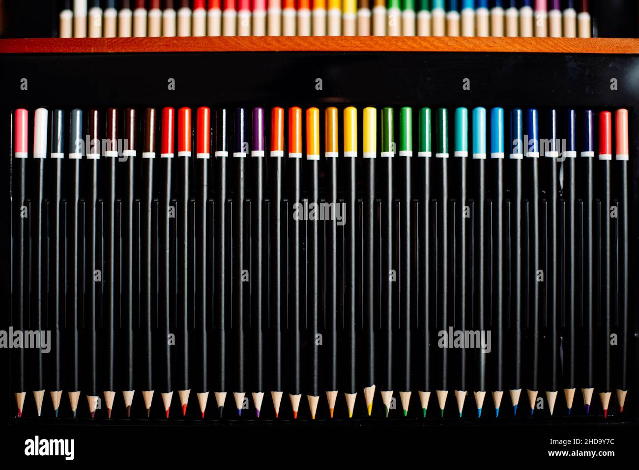 Color pencils for artistic drawing ordered by color gradient, on black ...