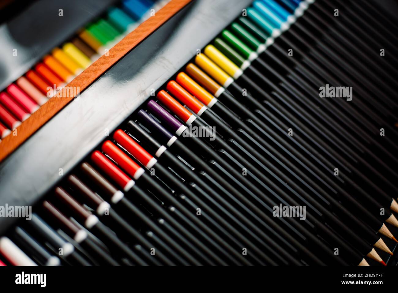 Color pencils for artistic drawing ordered by color gradient, on black ...