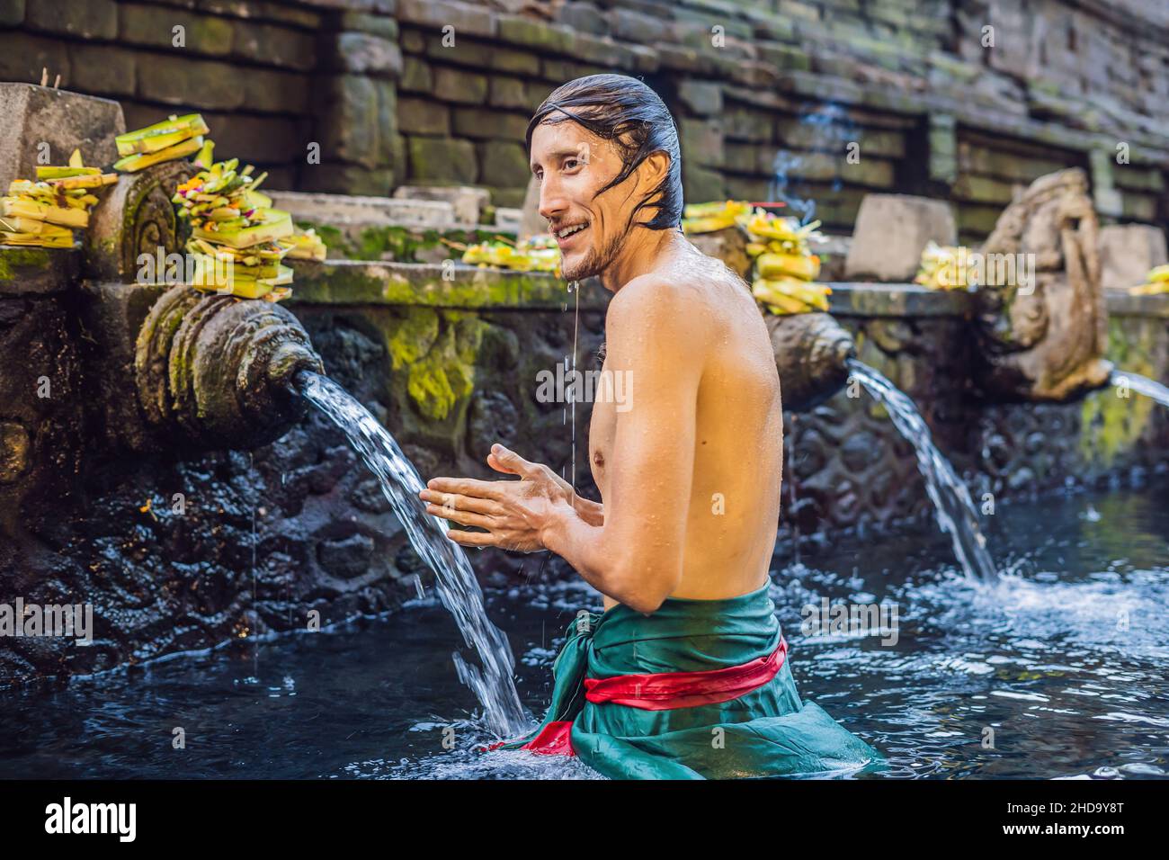 Man in holy spring water temple in bali. The temple compound consists ...