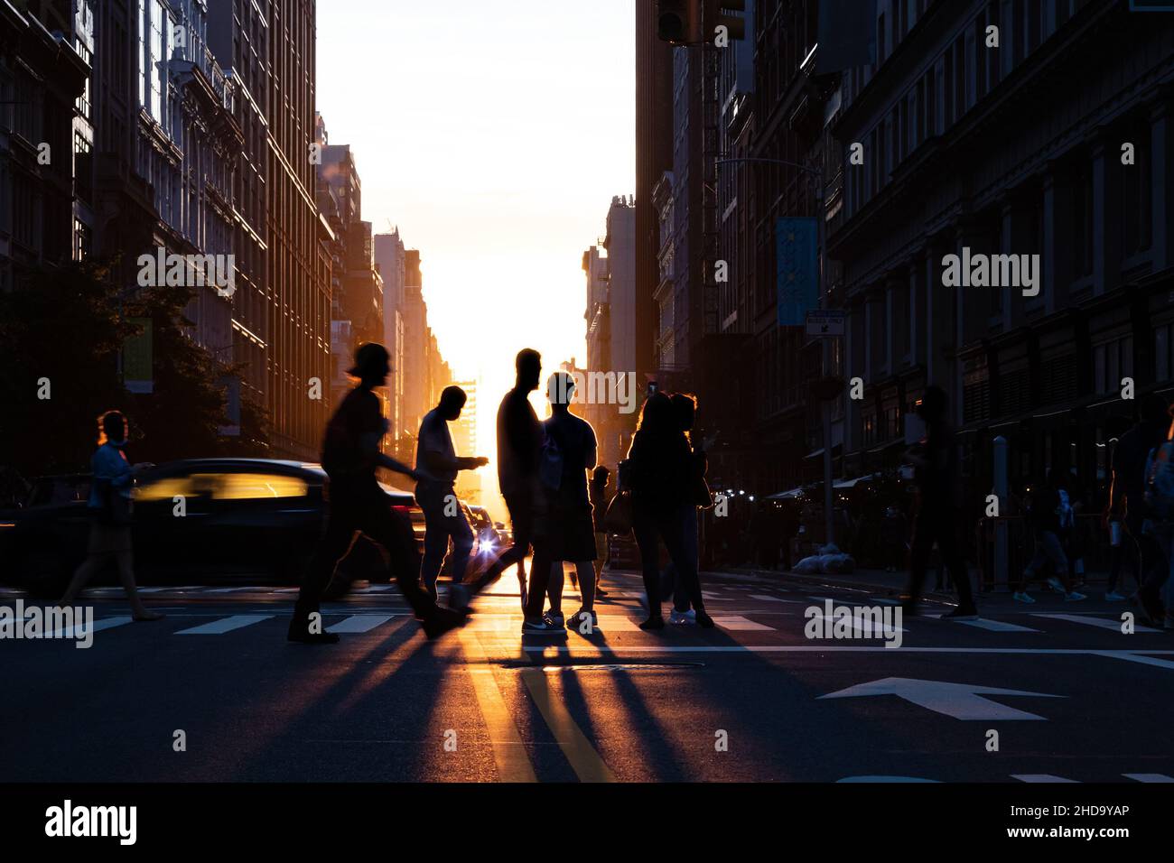 Silhouettes of people crossing a busy intersection on 5th Avenue in New ...