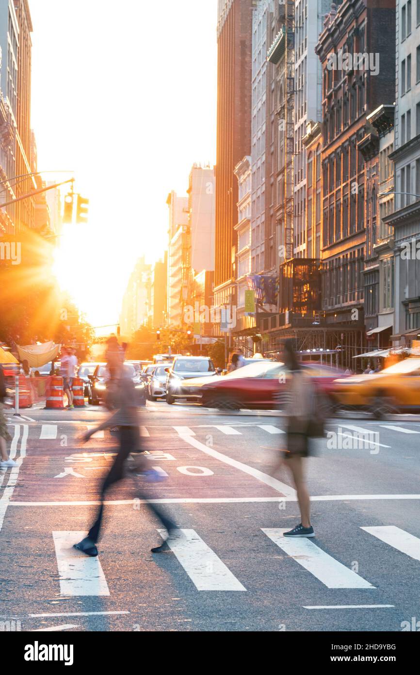 People in motion walking across a busy intersection on 5th Avenue in ...