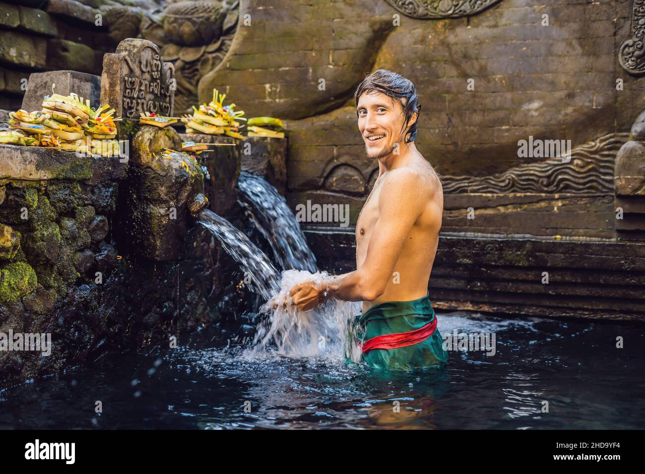 Man in holy spring water temple in bali. The temple compound consists ...