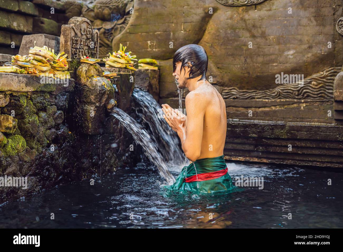 Man in holy spring water temple in bali. The temple compound consists ...