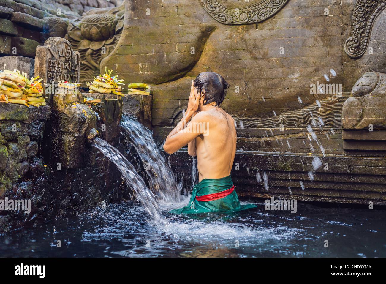 Man in holy spring water temple in bali. The temple compound consists ...