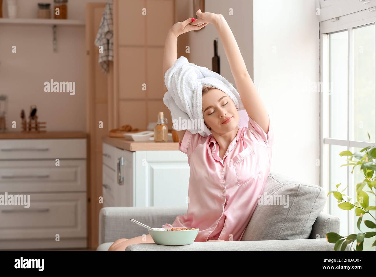 Pretty young woman stretching in sofa after shower Stock Photo - Alamy