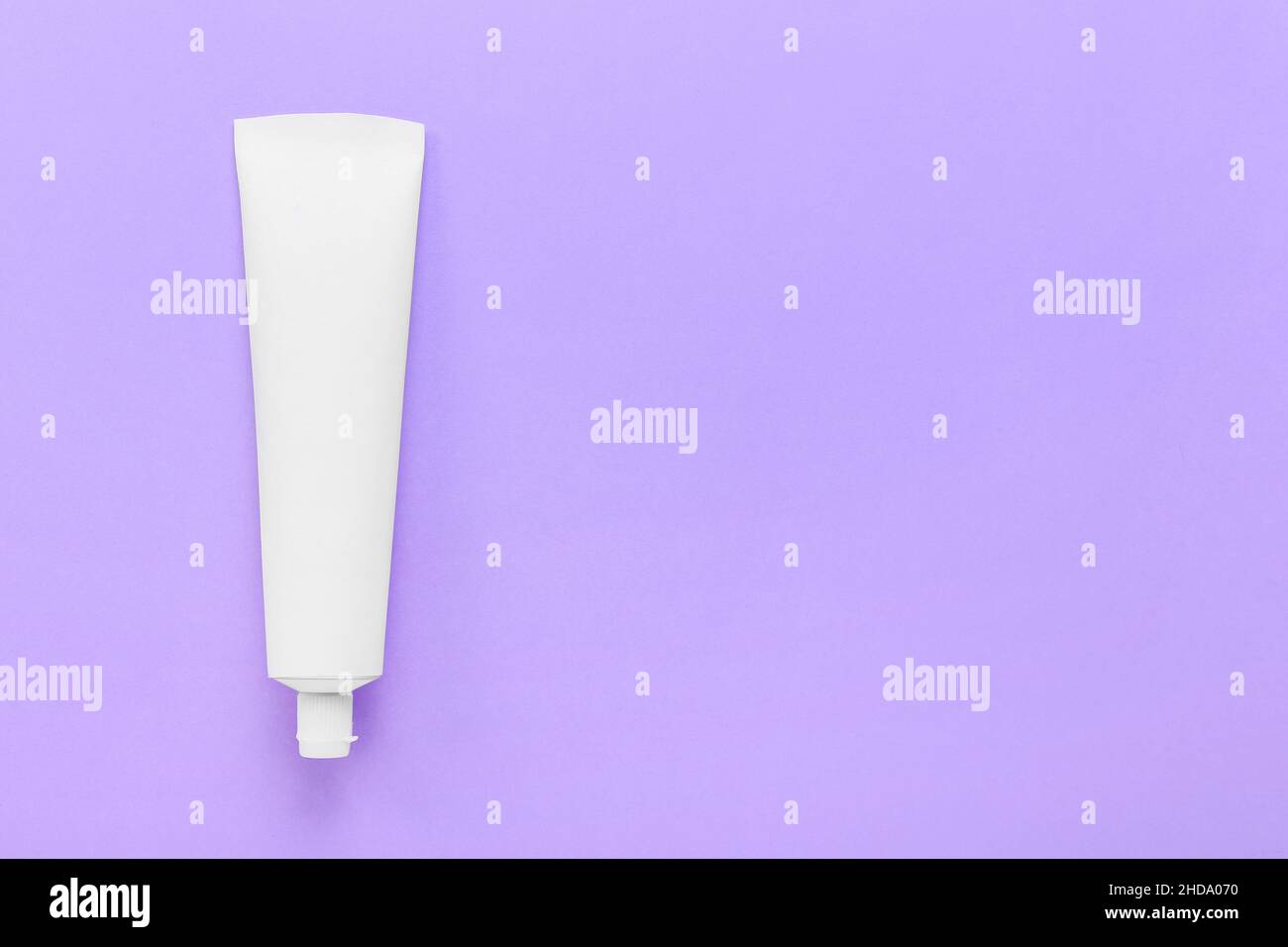 Tube with tooth paste on purple background Stock Photo - Alamy