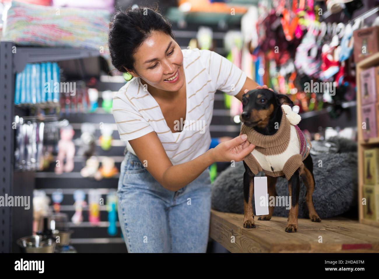 Woman dressing her dog in pet shop Stock Photo - Alamy