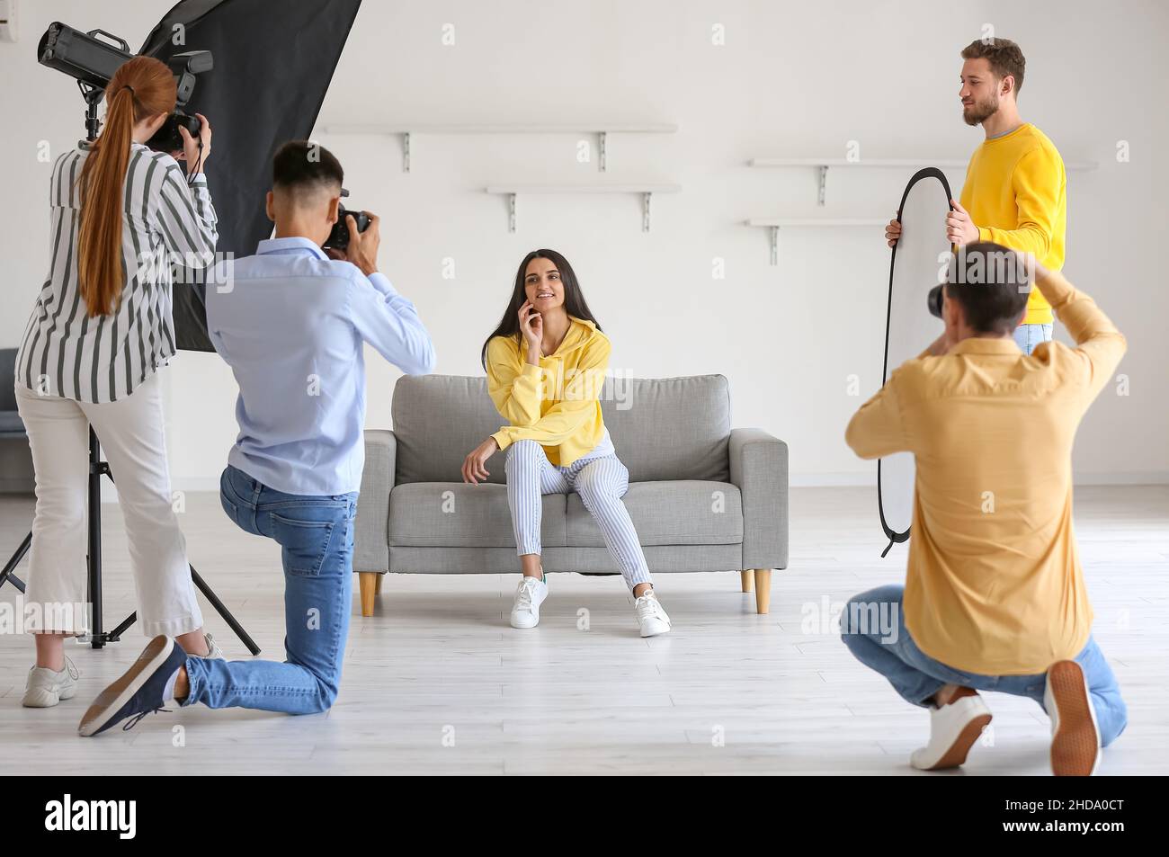 Young photographers taking picture of model in studio Stock Photo - Alamy