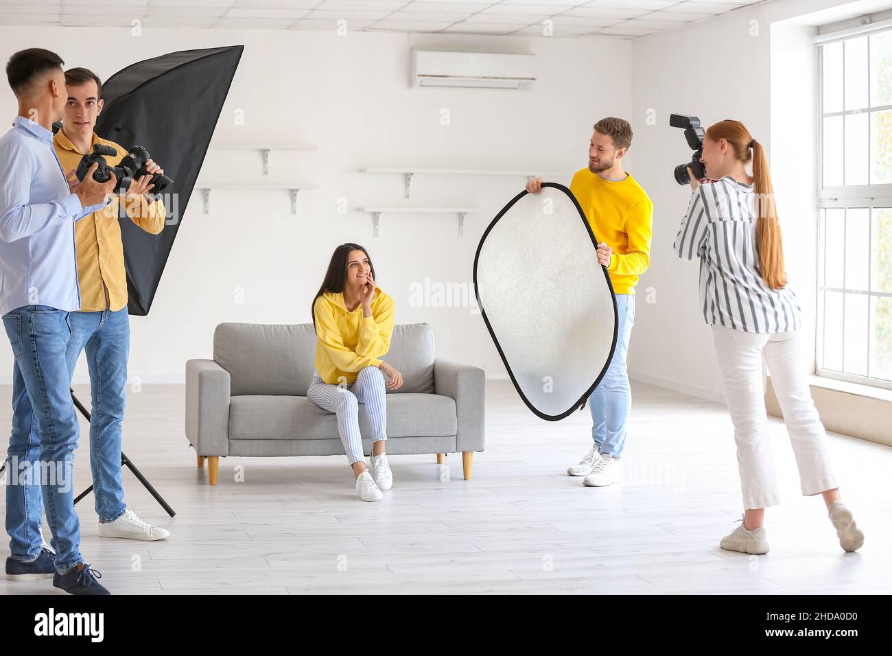 Young photographers taking picture of model in studio Stock Photo - Alamy