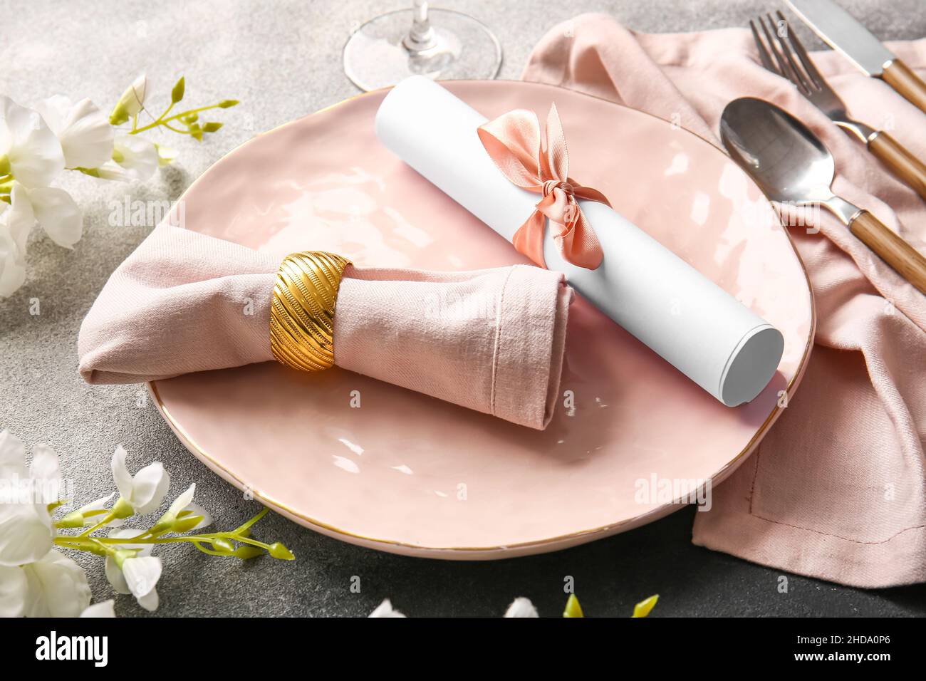 Beautiful table setting with wedding invitation and flowers on grunge ...