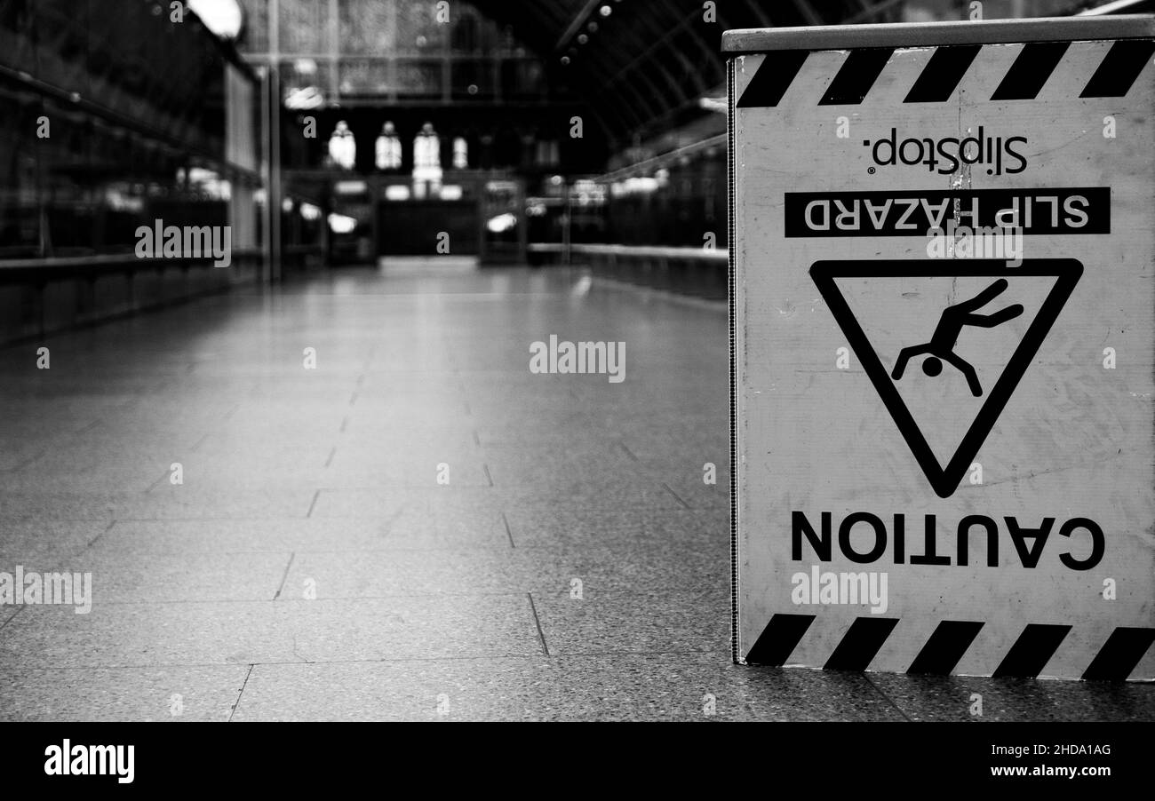 Slip hazard sign (slip stop) upside down in a train station Stock Photo ...