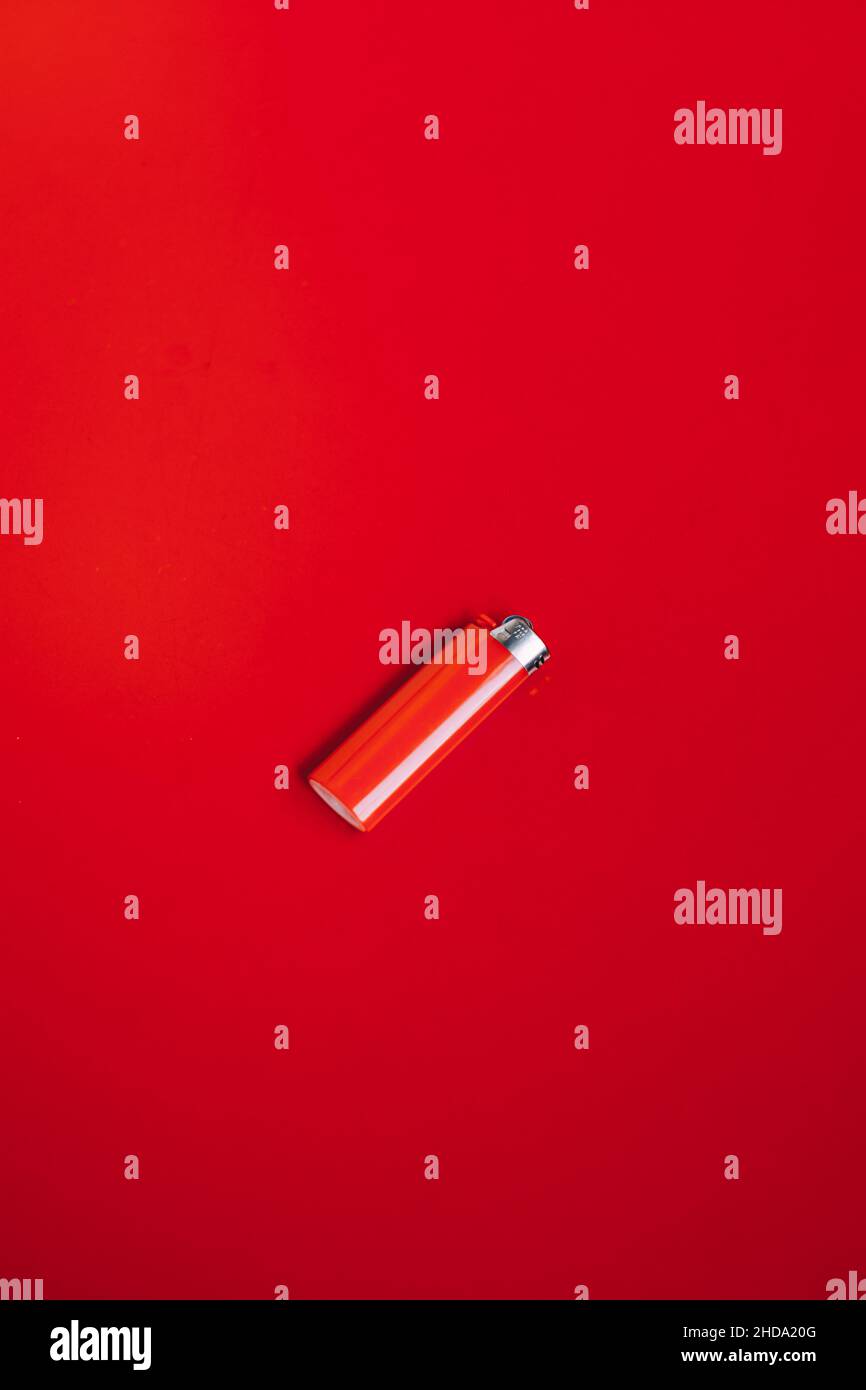 Shot of a small red lighter on a red isolated background Stock Photo ...