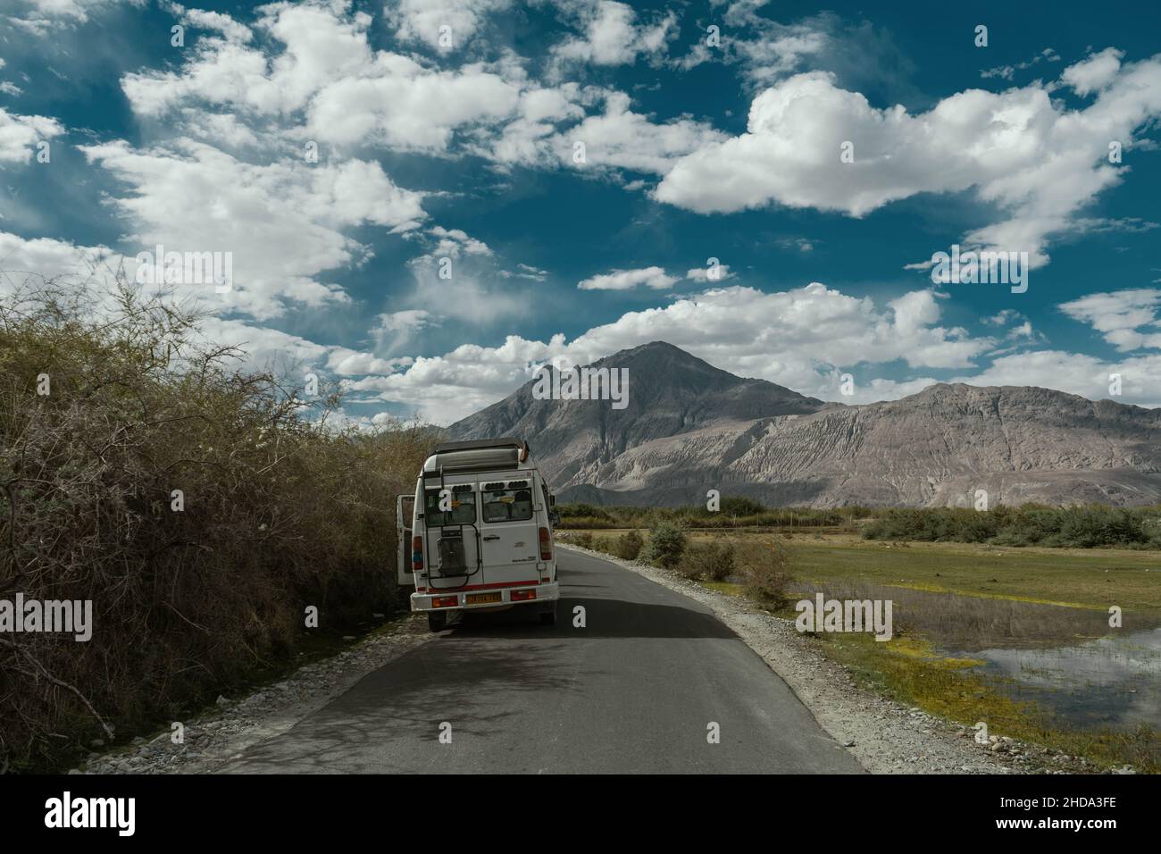 Old car on a rural road under a bright sky in Ladakh, India Stock Photo ...