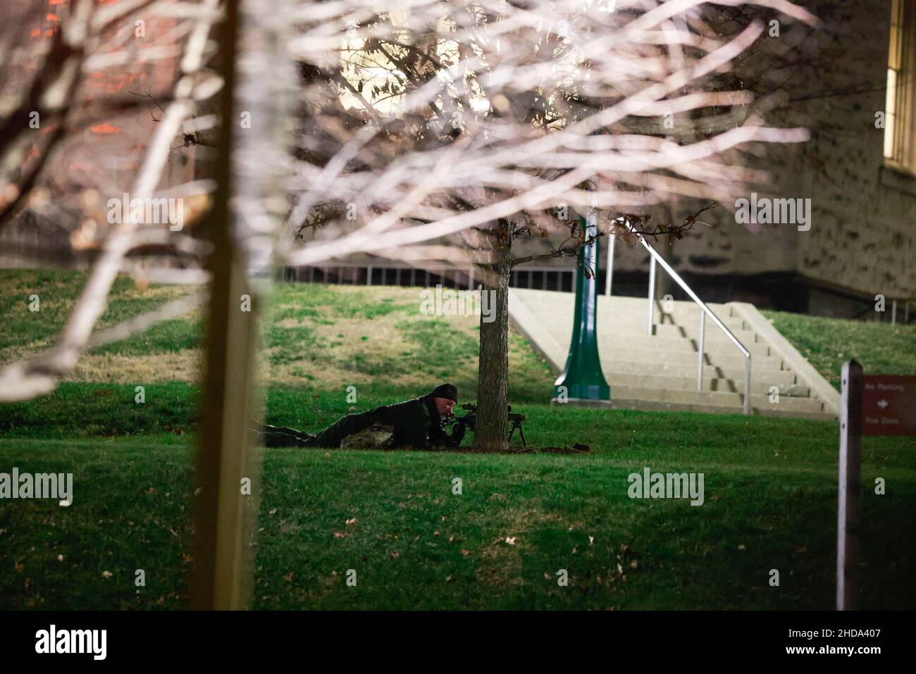 A members of the Critical Incident Response Team (CIRT) aims a rifle at ...