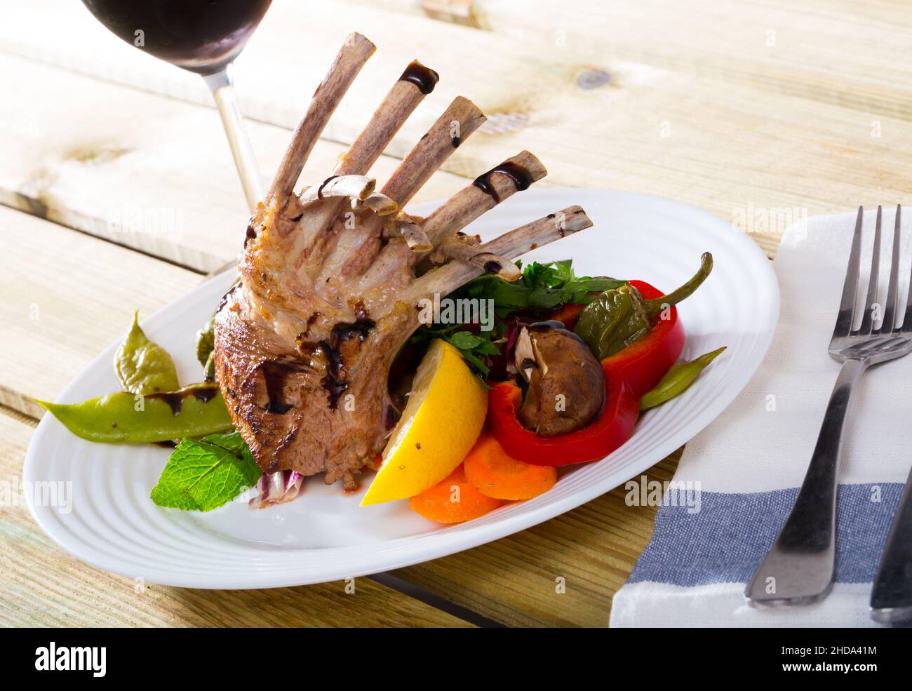 Roasted rack of mutton with vegetables and red wine Stock Photo - Alamy