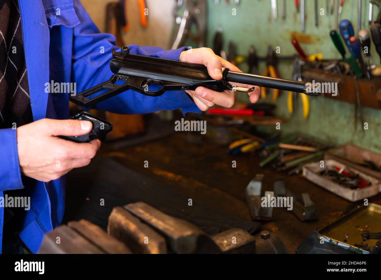 Dismantling and repair of combat pistol in weapons workshop Stock Photo ...