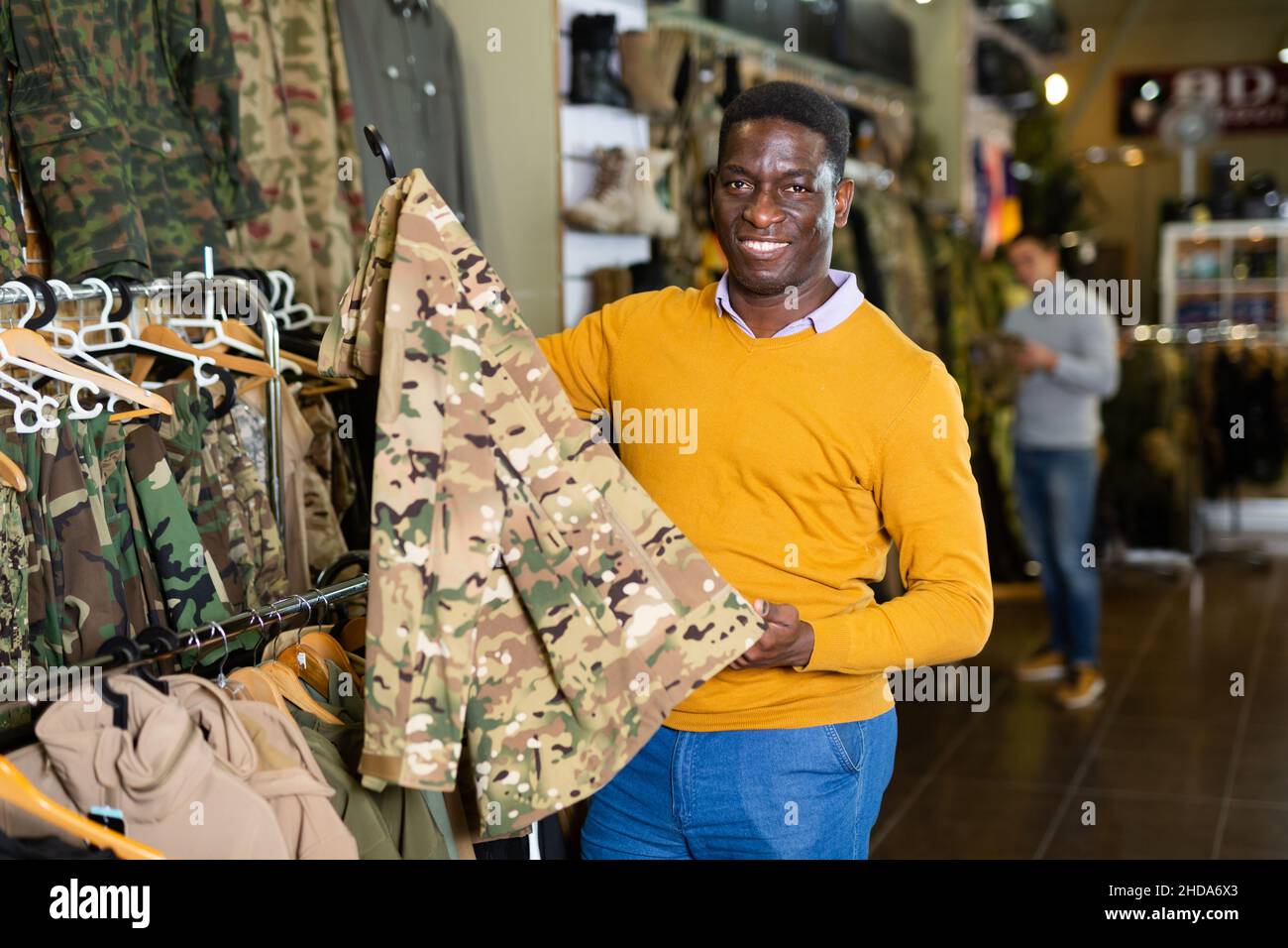Male shopper chooses camouflage uniform at army store Stock Photo - Alamy