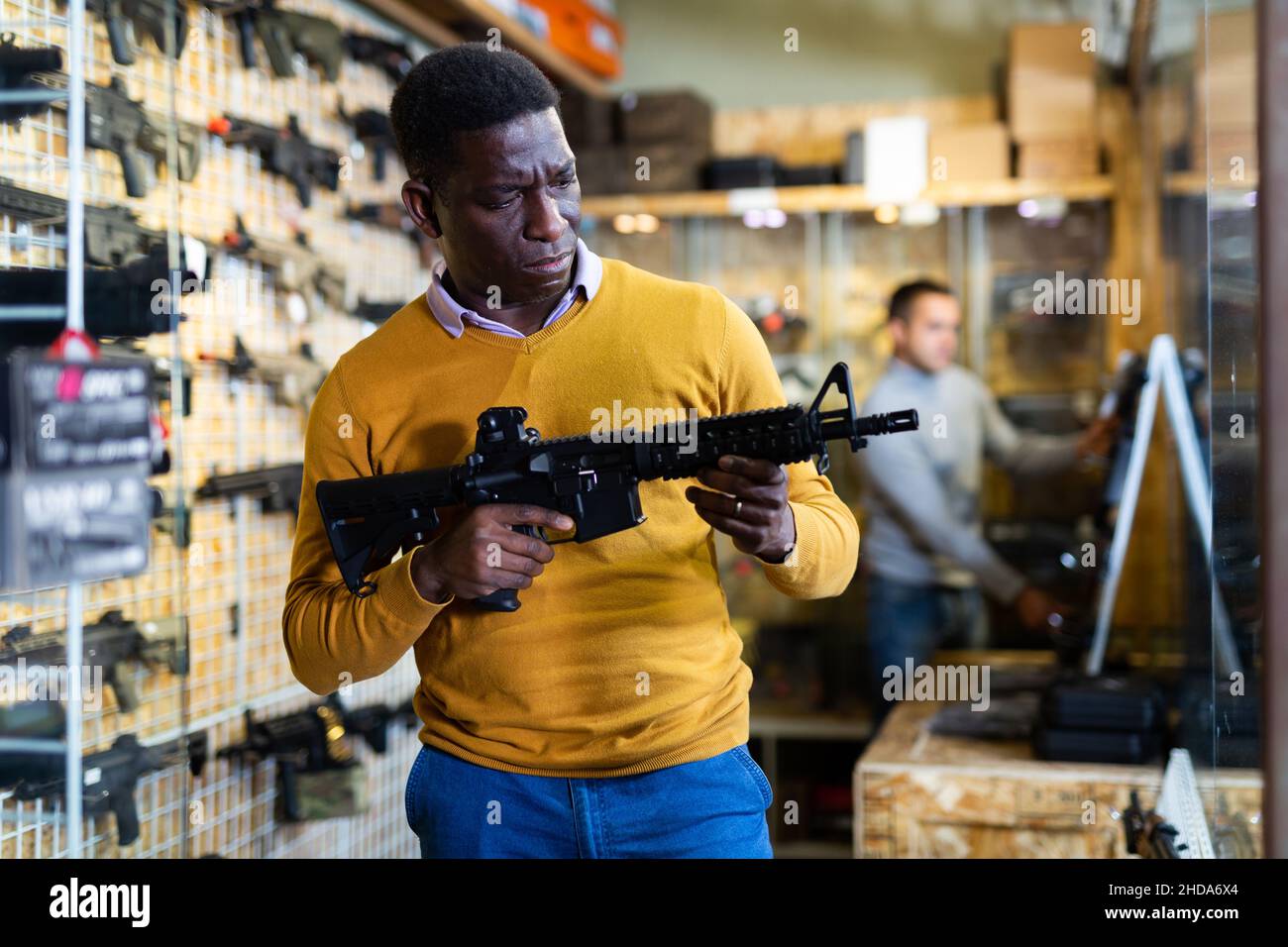 Portrait of african american man in gun shop showing rifle Stock Photo ...