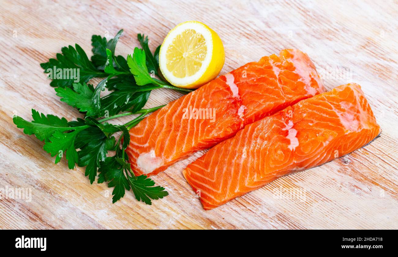 Raw red fish salmon fillet, lemon, parsley Stock Photo - Alamy