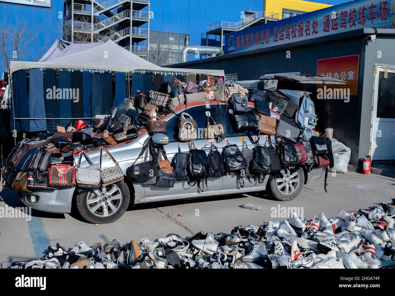 on a weekends bazaar, a vendor's car is covered with new bags to sell ...