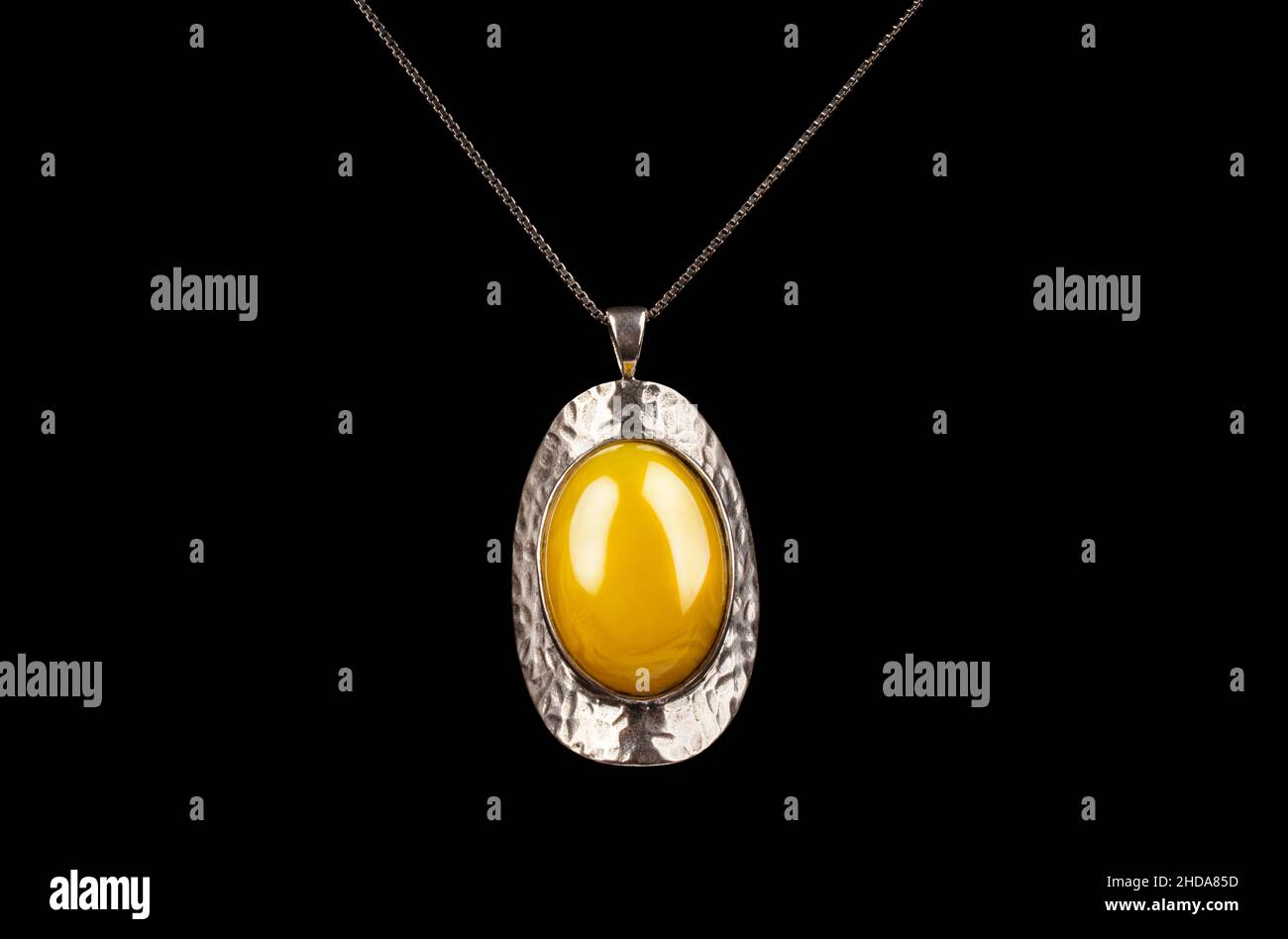 Silver jewelry pendant with chinese amber isolated on black background ...