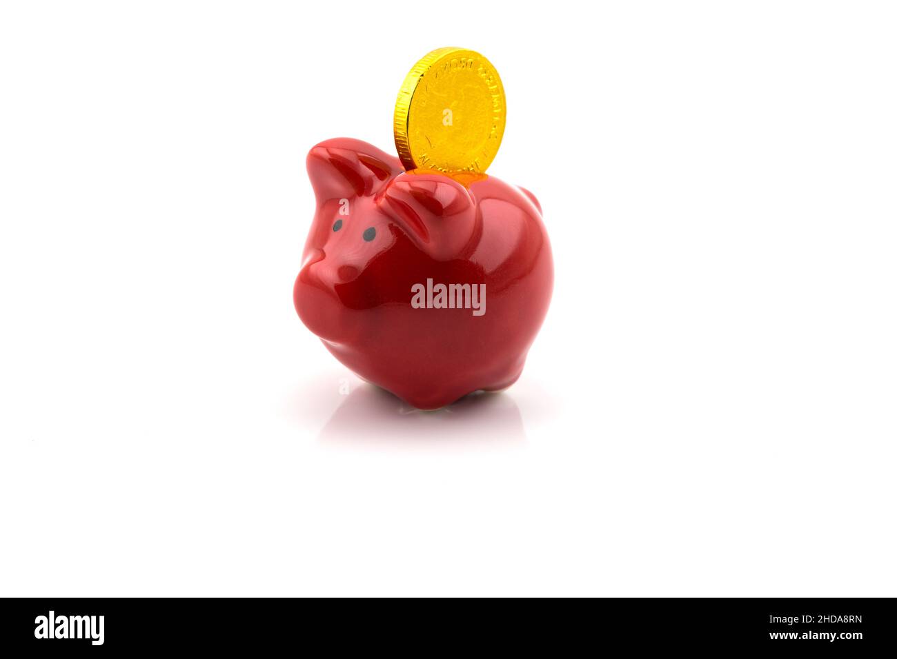 Big gold coin into a red pig bank isolated on white background Stock ...