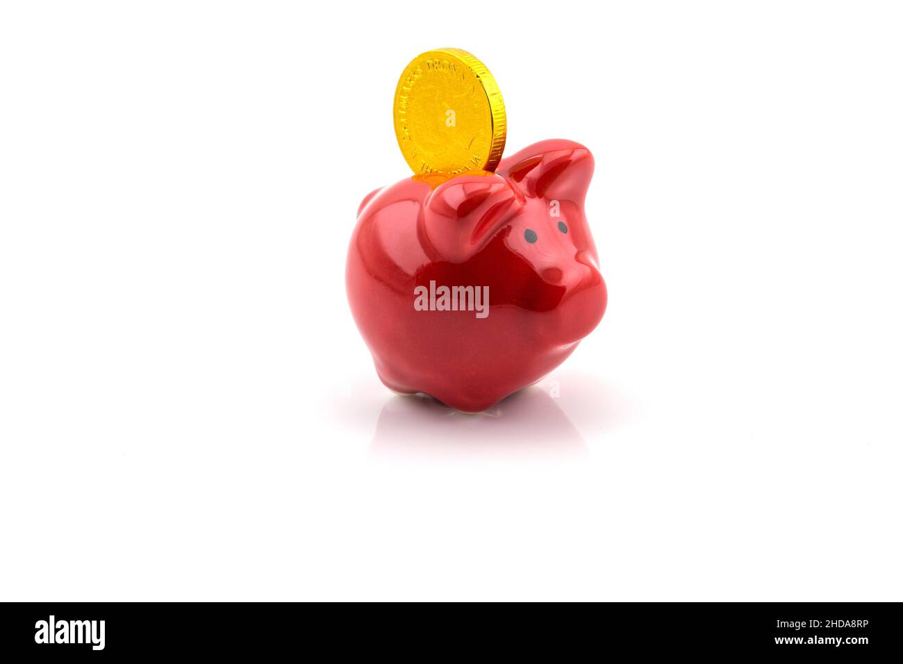 Big gold coin into a red pig bank isolated on white background Stock ...