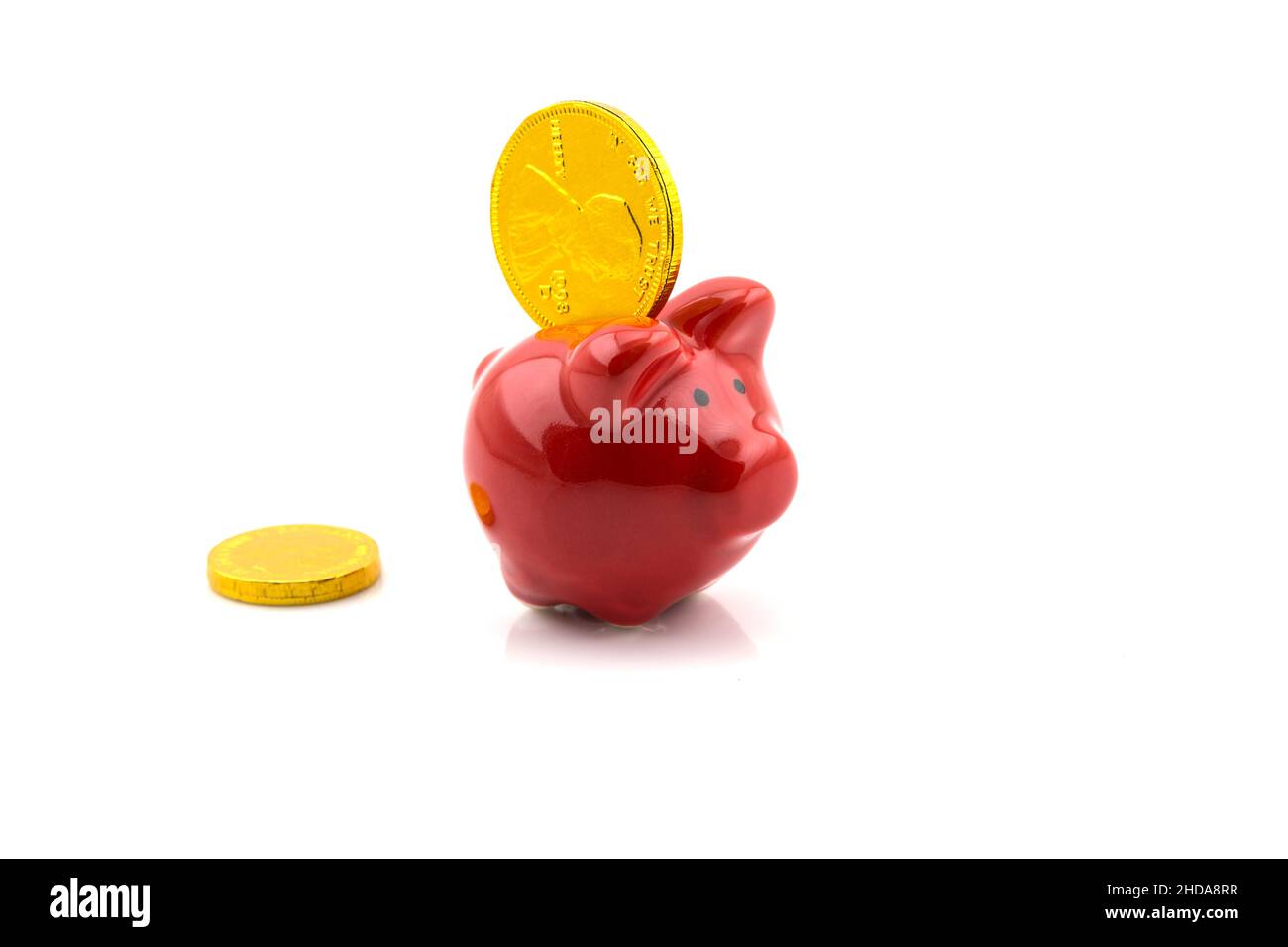 Big gold coin into a red pig bank isolated on white background Stock ...