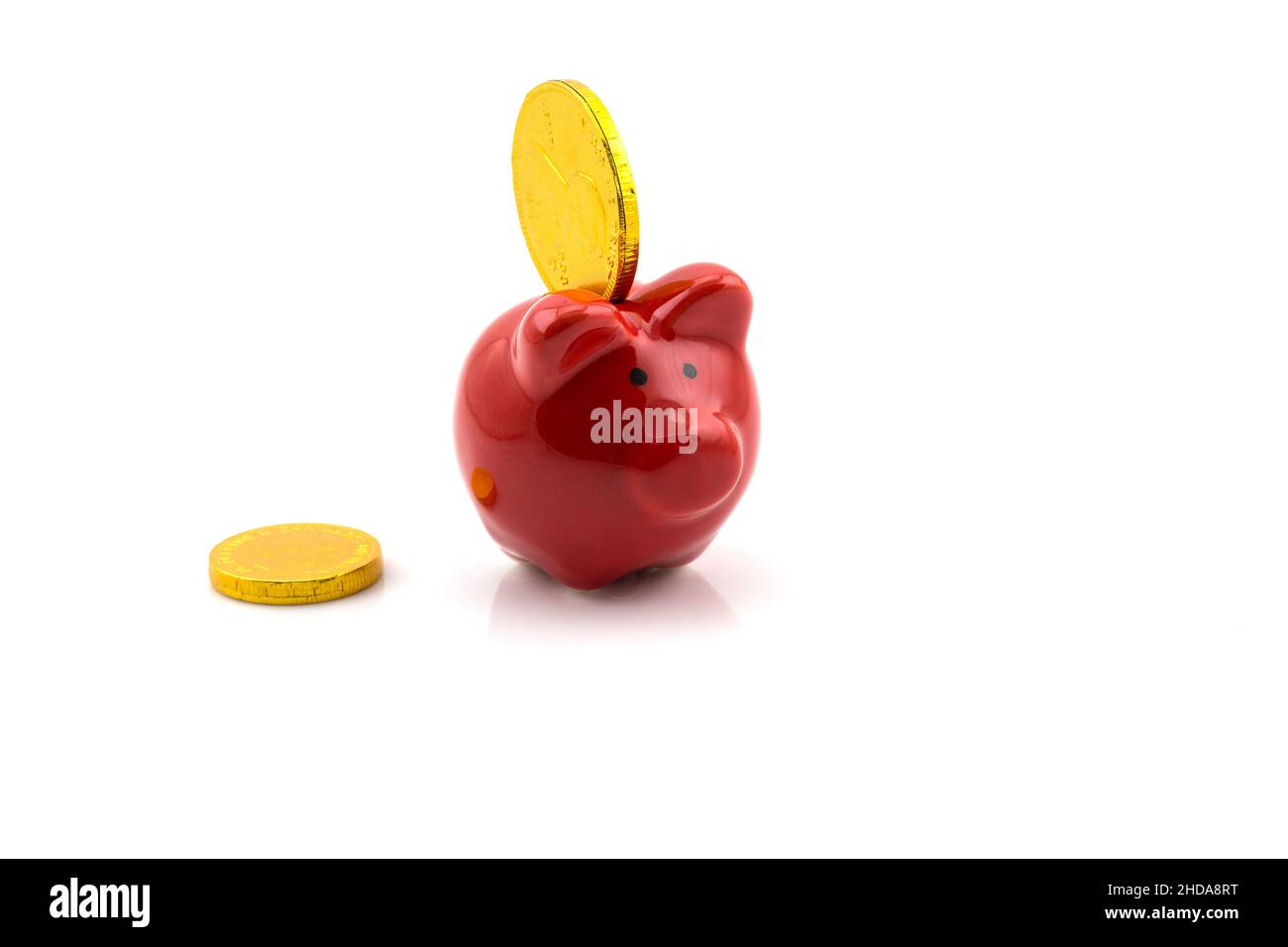 Big gold coin into a red pig bank isolated on white background Stock ...