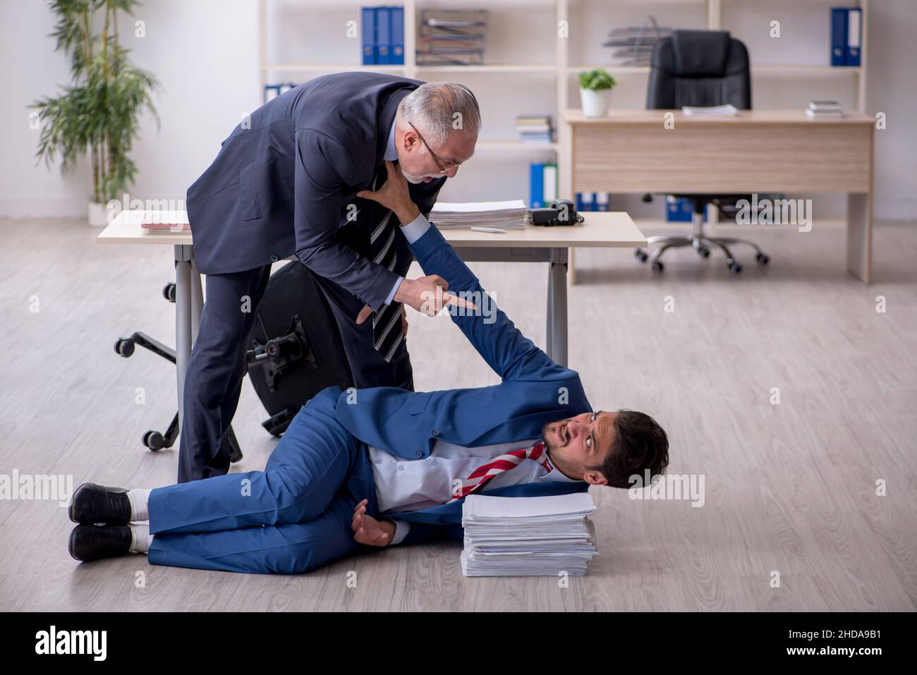 Old boss and young employee in bullying concept Stock Photo - Alamy