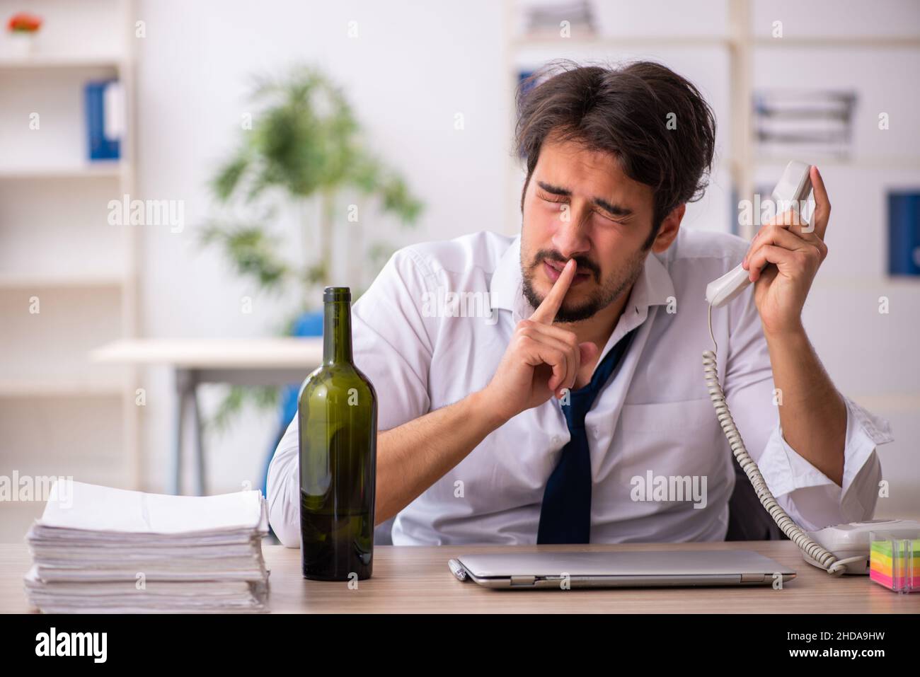 Male alcohol addicted employee sitting in the office Stock Photo - Alamy