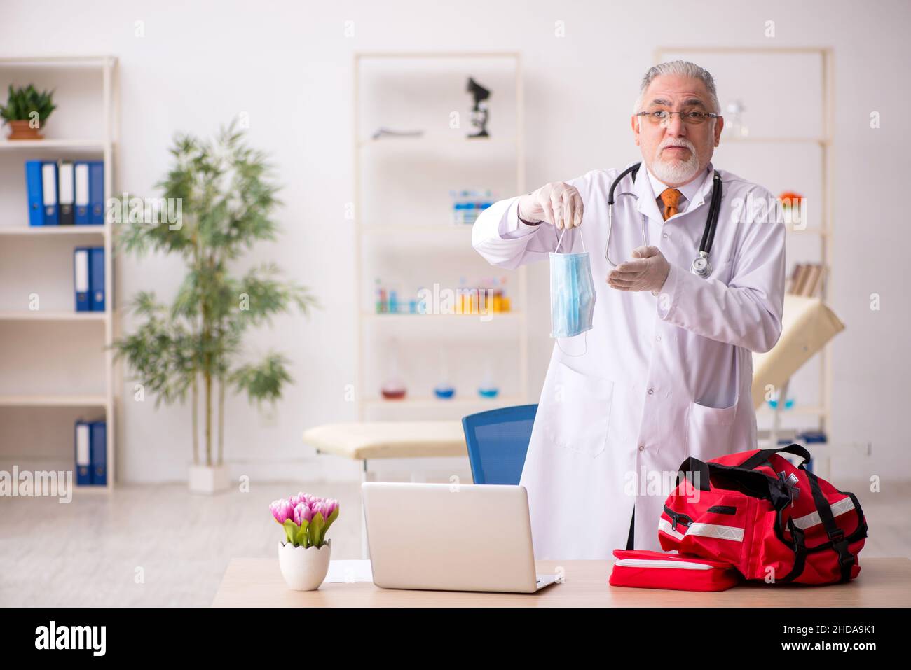 Old doctor in first aid concept Stock Photo - Alamy