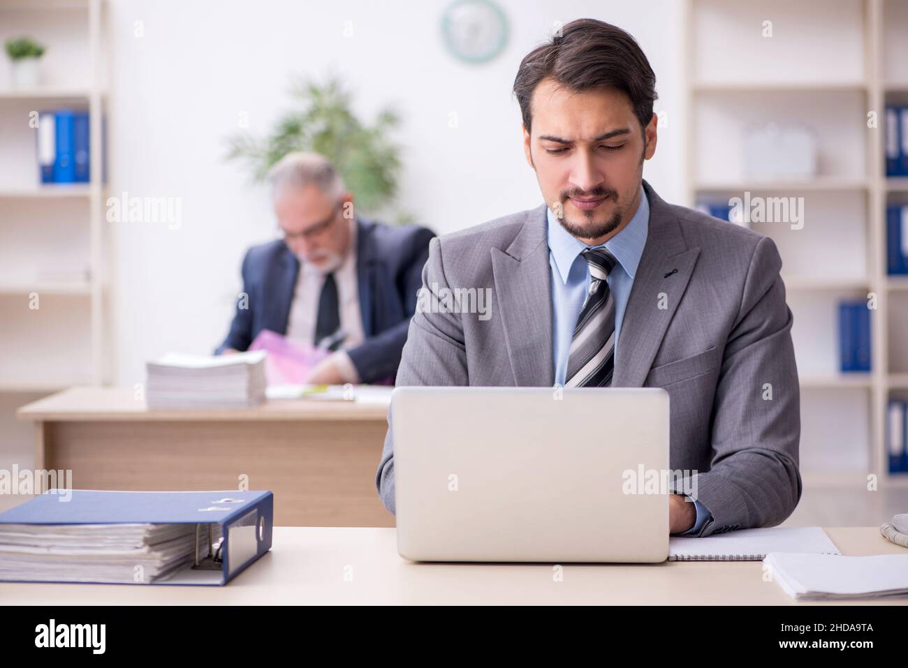 Two male employees working at workplace Stock Photo - Alamy