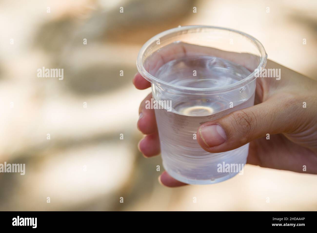 Female hand holding water glass background Stock Photo - Alamy