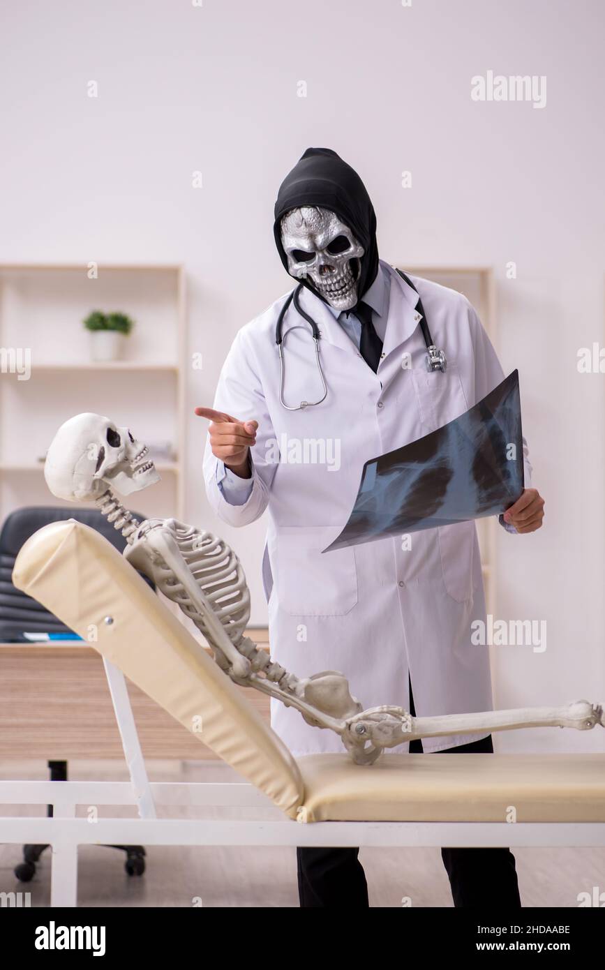 Devil doctor radiologist examining skeleton patient at the hospital ...