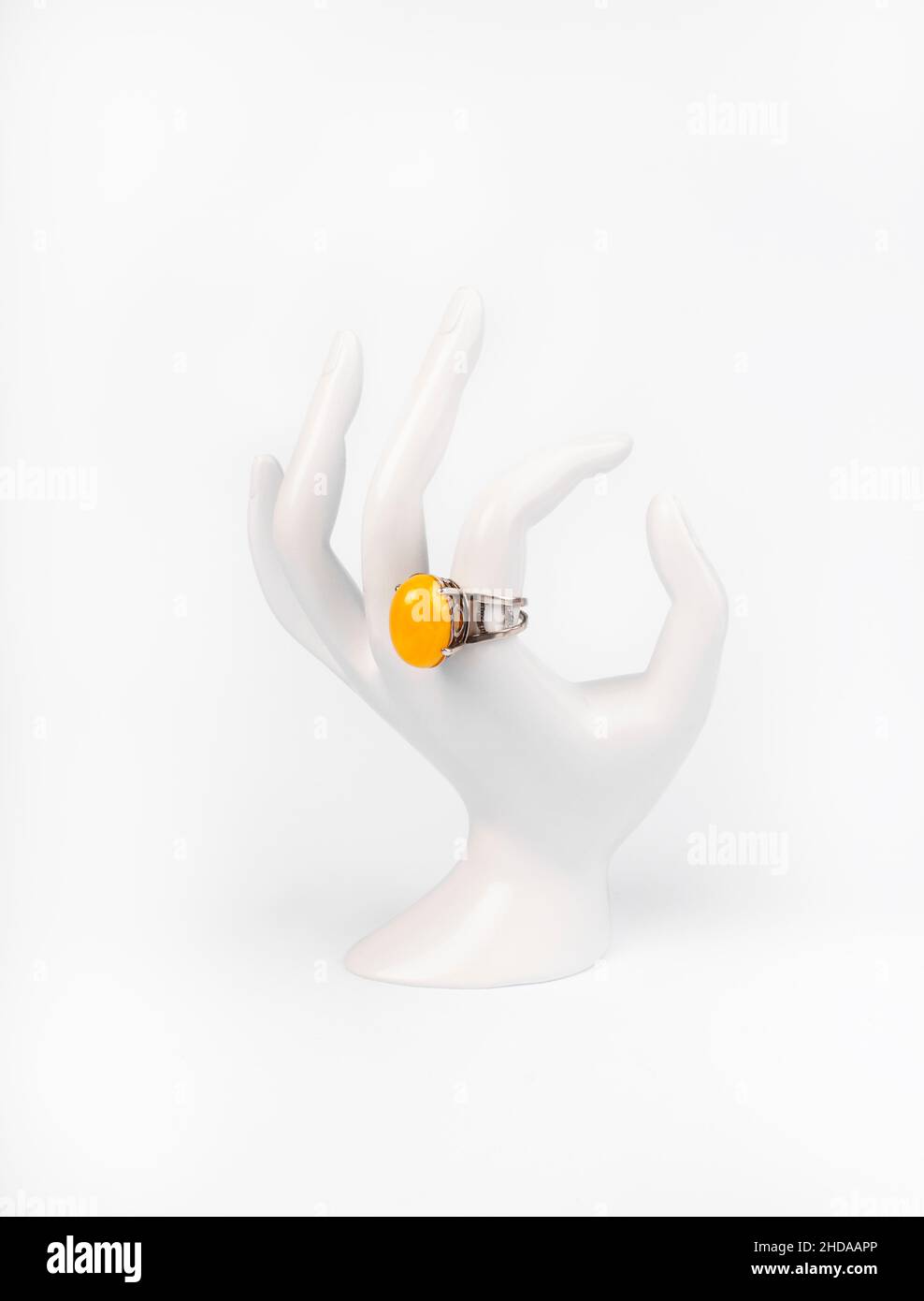 Plastic white hand with silver ring and chinese amber on white ...