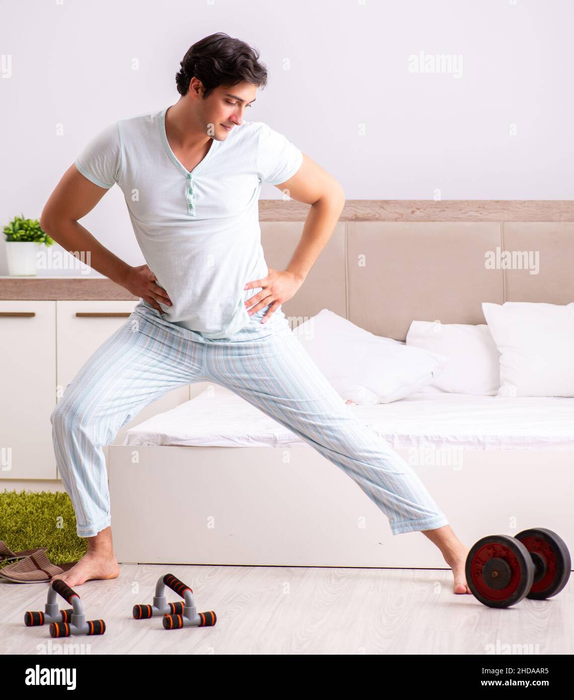 The young man doing morning routine in bedroom Stock Photo - Alamy