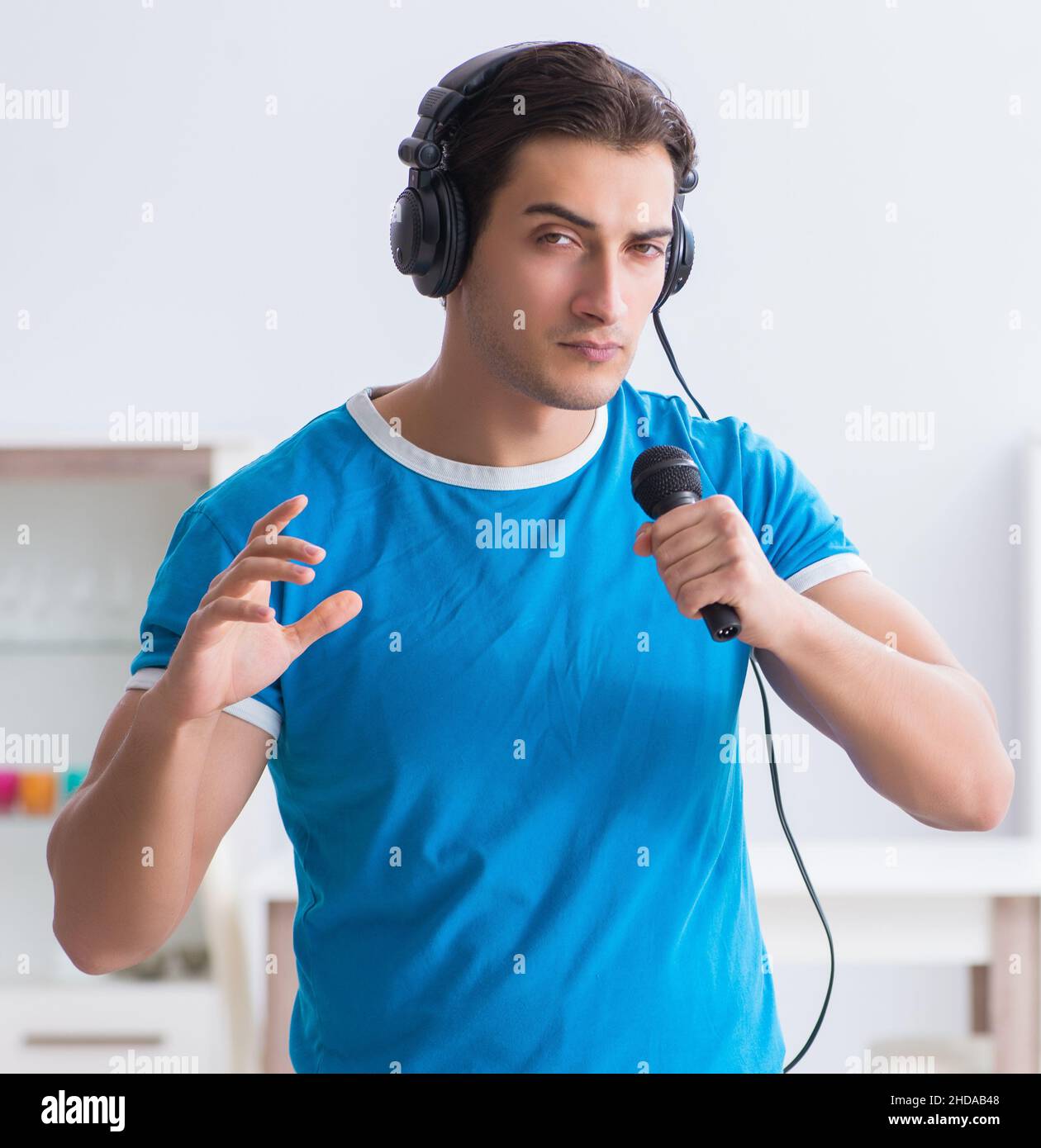 The young handsome man singing karaoke at home Stock Photo - Alamy