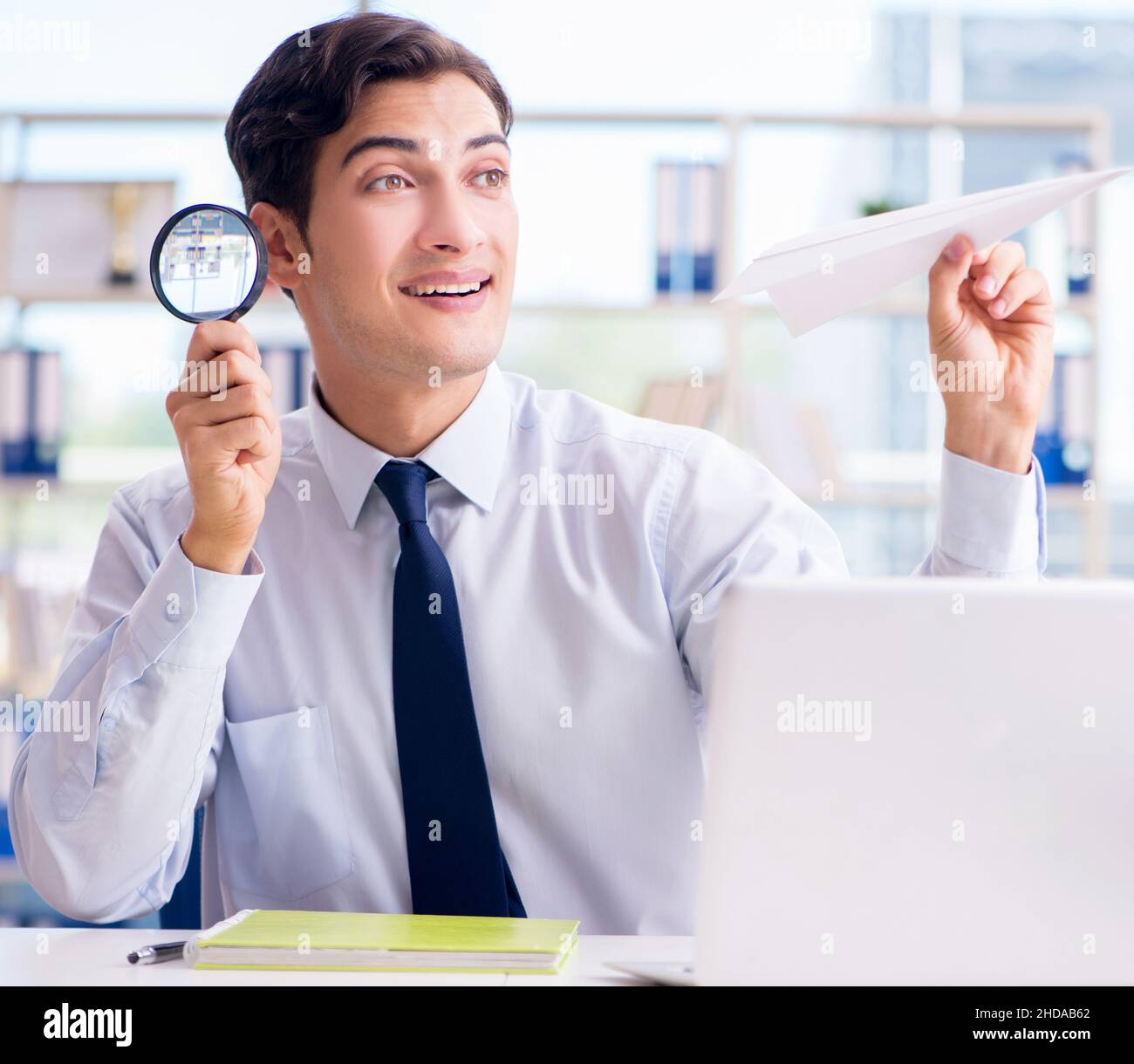 The businessman with magnifying glass and paper plane Stock Photo - Alamy