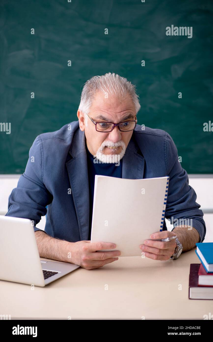 Old teacher in the classroom Stock Photo - Alamy
