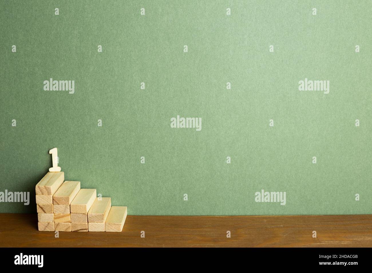 Wood block stairs with number on desk. green background. development ...