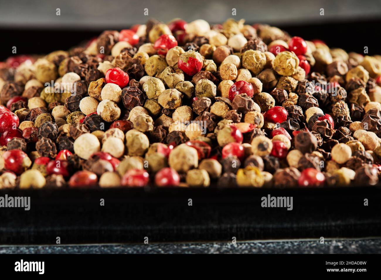 Multi-colored peppercorns on black plate with reflection Stock Photo ...