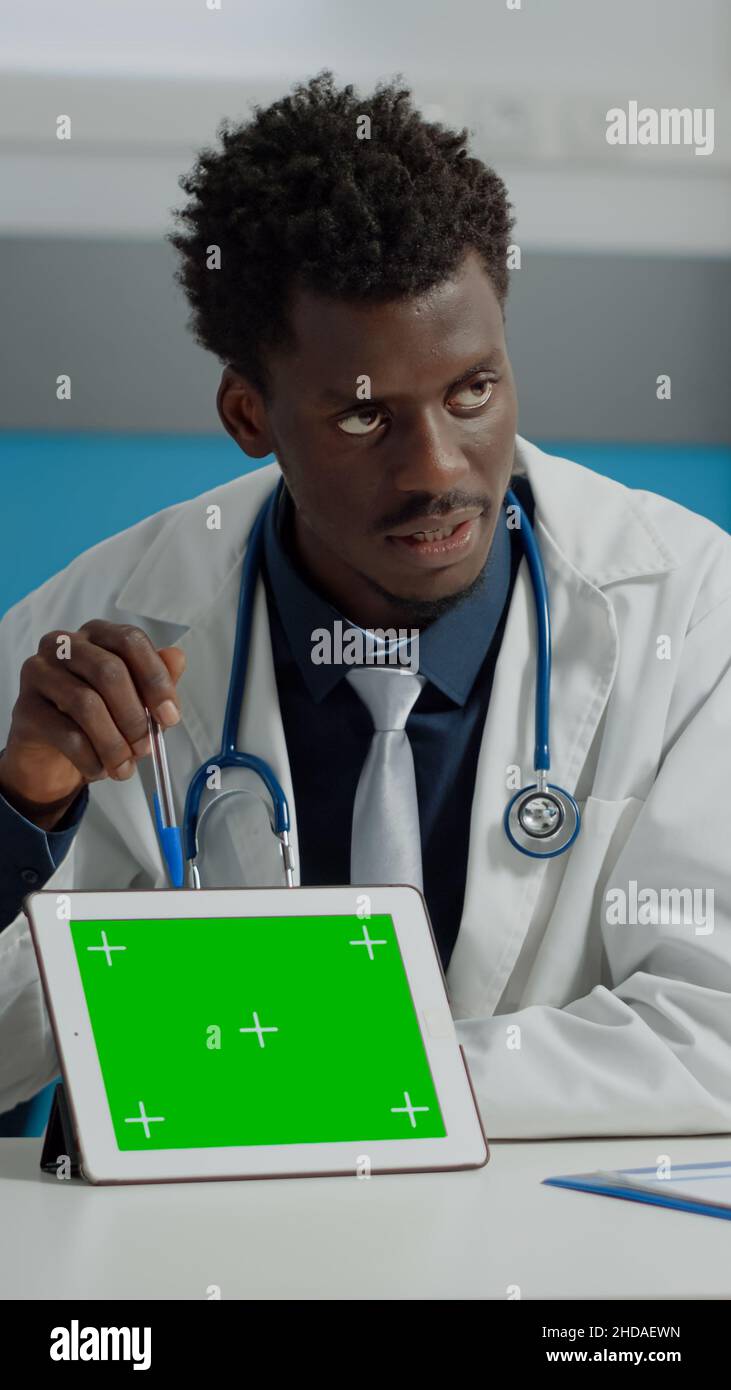 Medic using professional tablet with horizontal green screen display ...