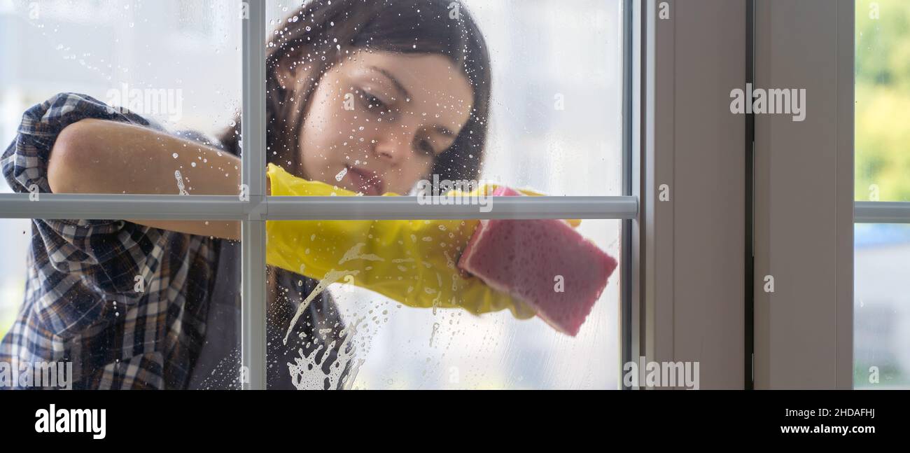 Woman washes the windows with a detergent Stock Photo - Alamy