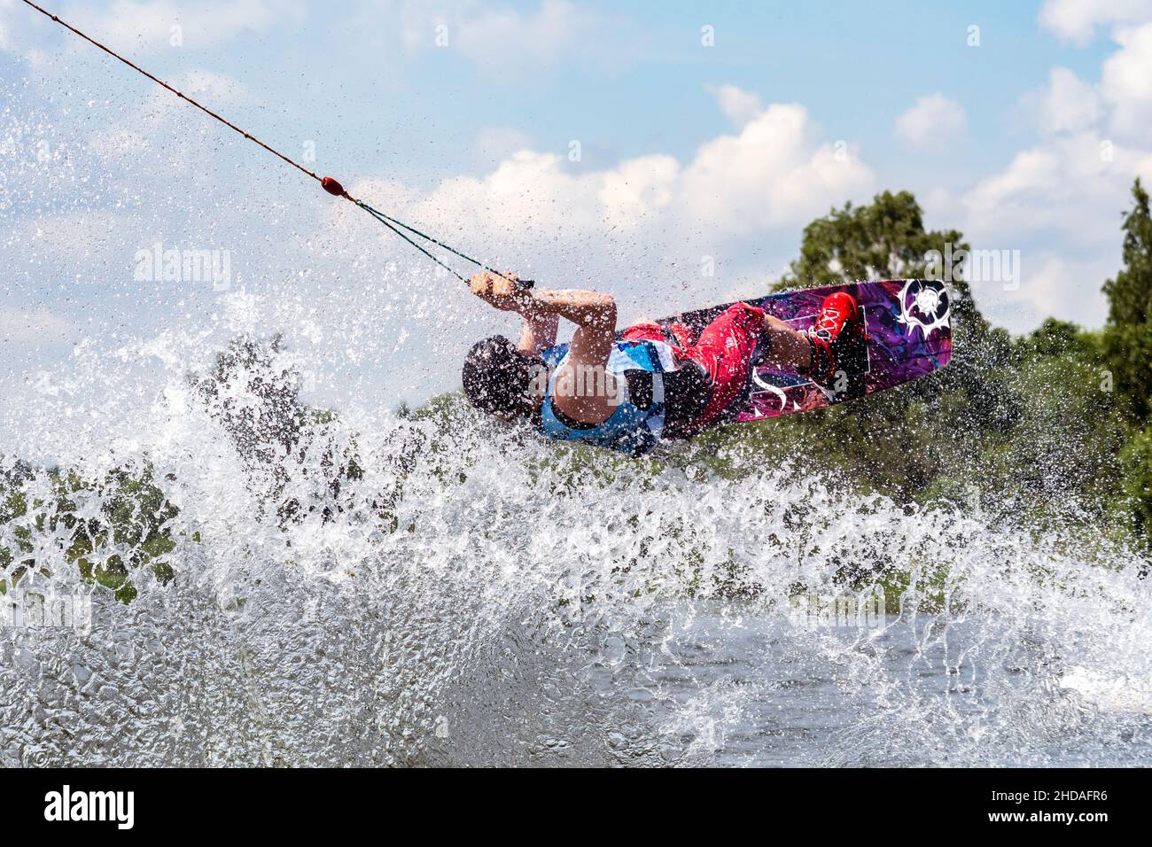 young active professional athlete jumping in the air on a wakeboard ...
