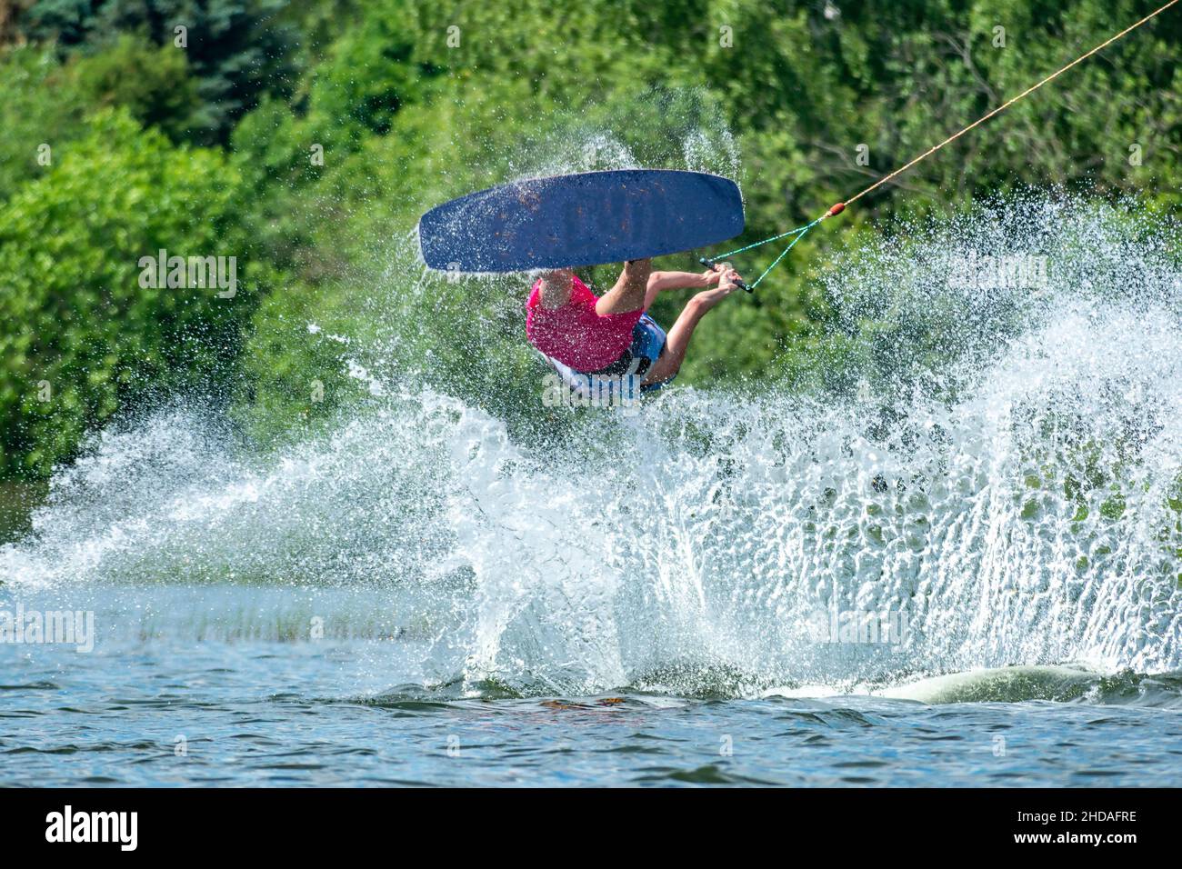 young active professional athlete jumping in the air on a wakeboard ...