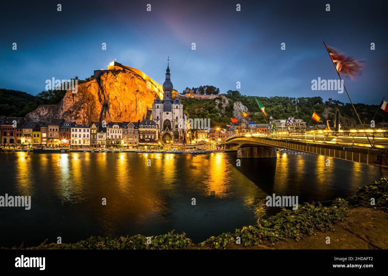 Dramatic night scene of Dinant ton and its bridge with flags Stock ...